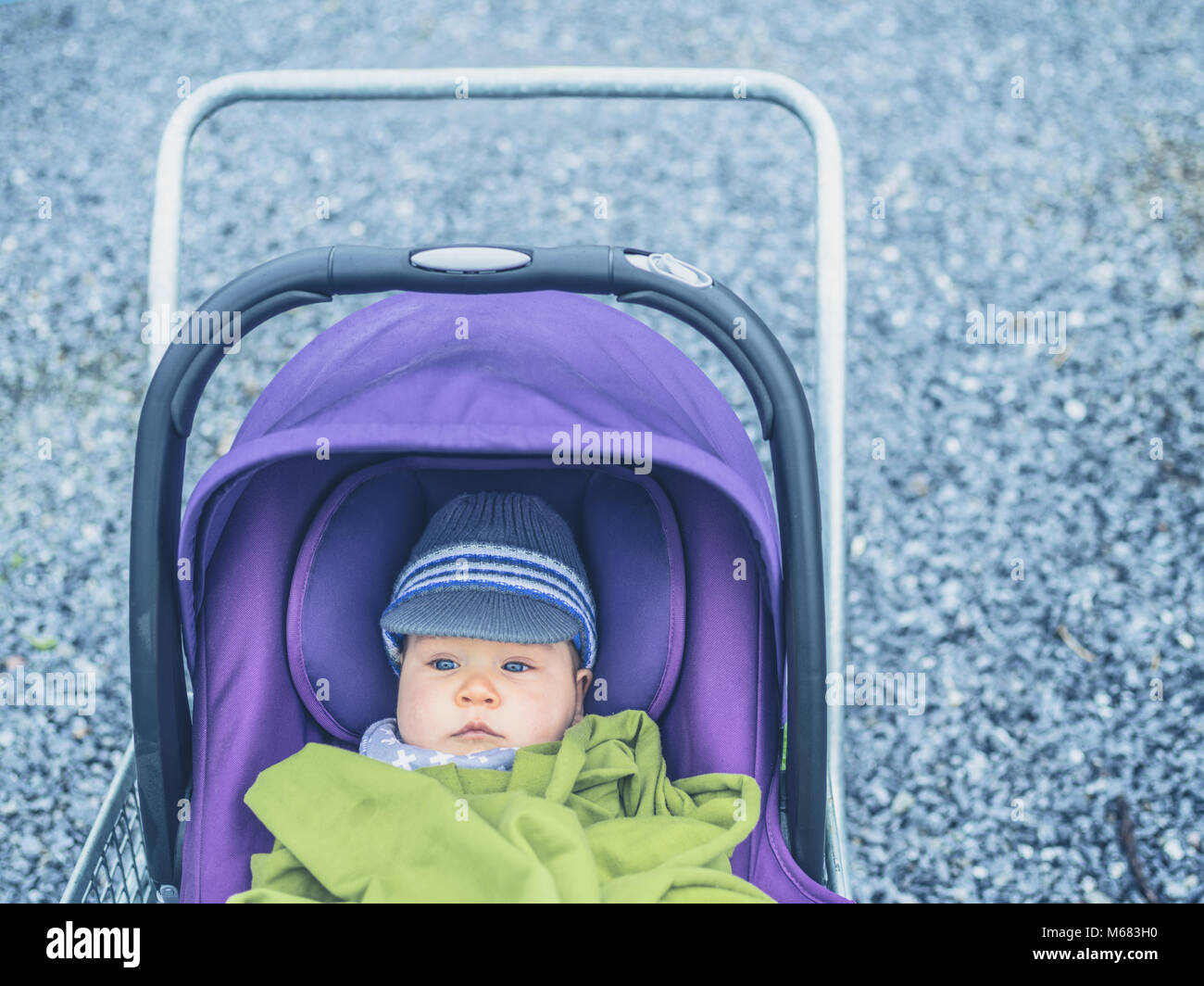 A little baby is sitting in a pram outside on a cold day Stock Photo ...