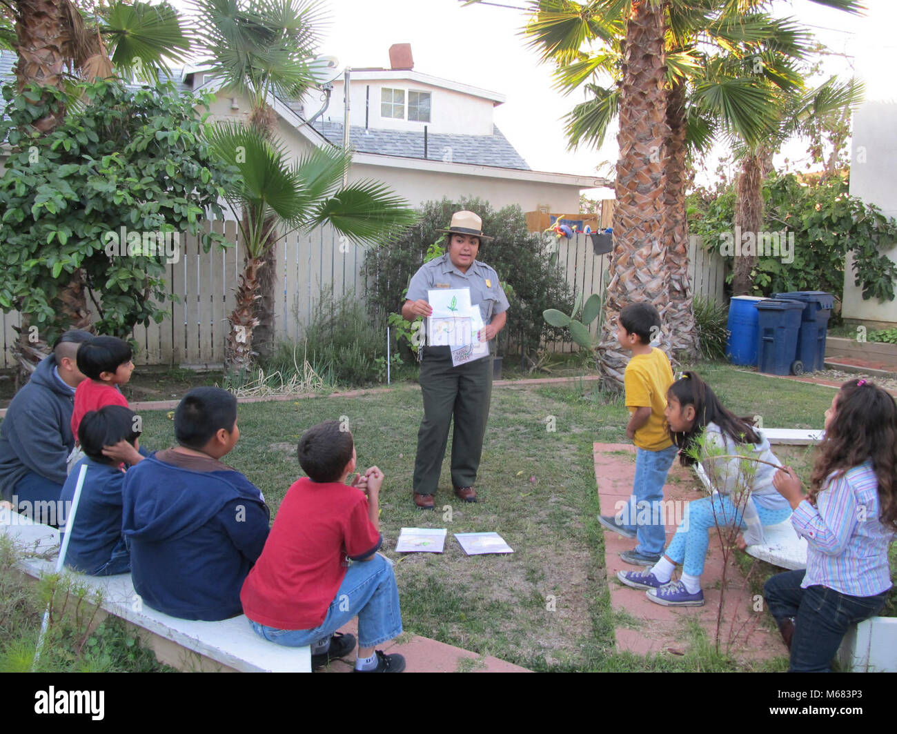 Ranger with Children. A park ranger helps youngsters identify native ...