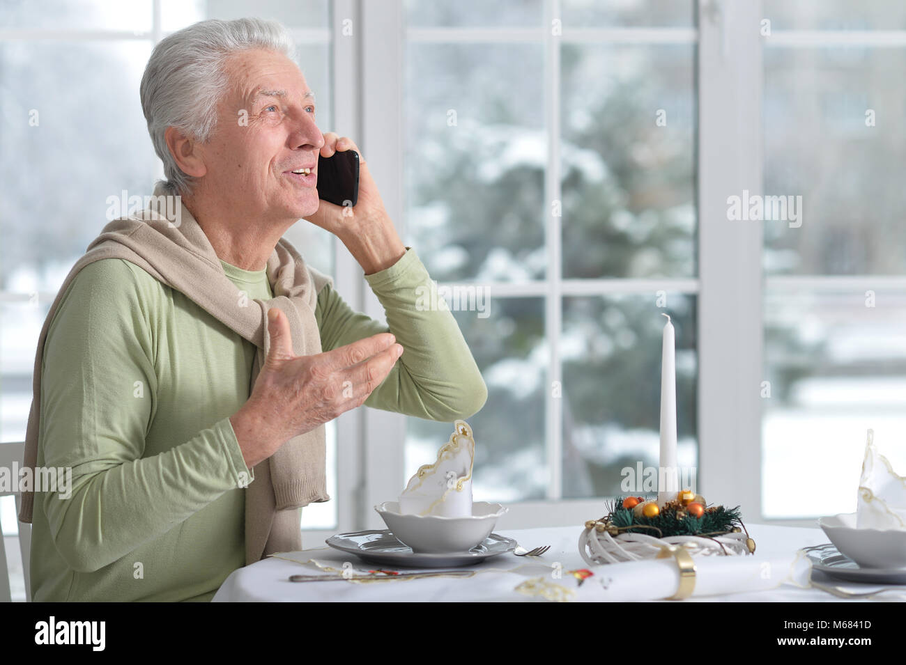 sad senior man talking on phone while sitting Stock Photo - Alamy