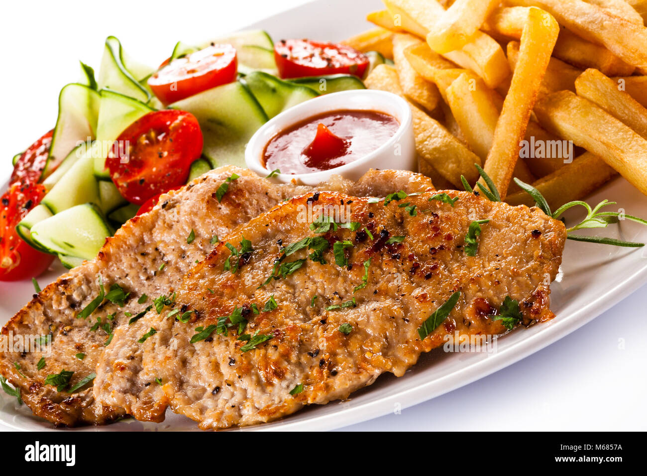 Fried pork chop, French fries and vegetables isolated on white ...