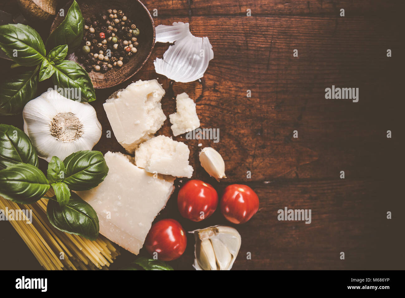 Top view of cheese and vegetables with pasta on rough wooden table ...
