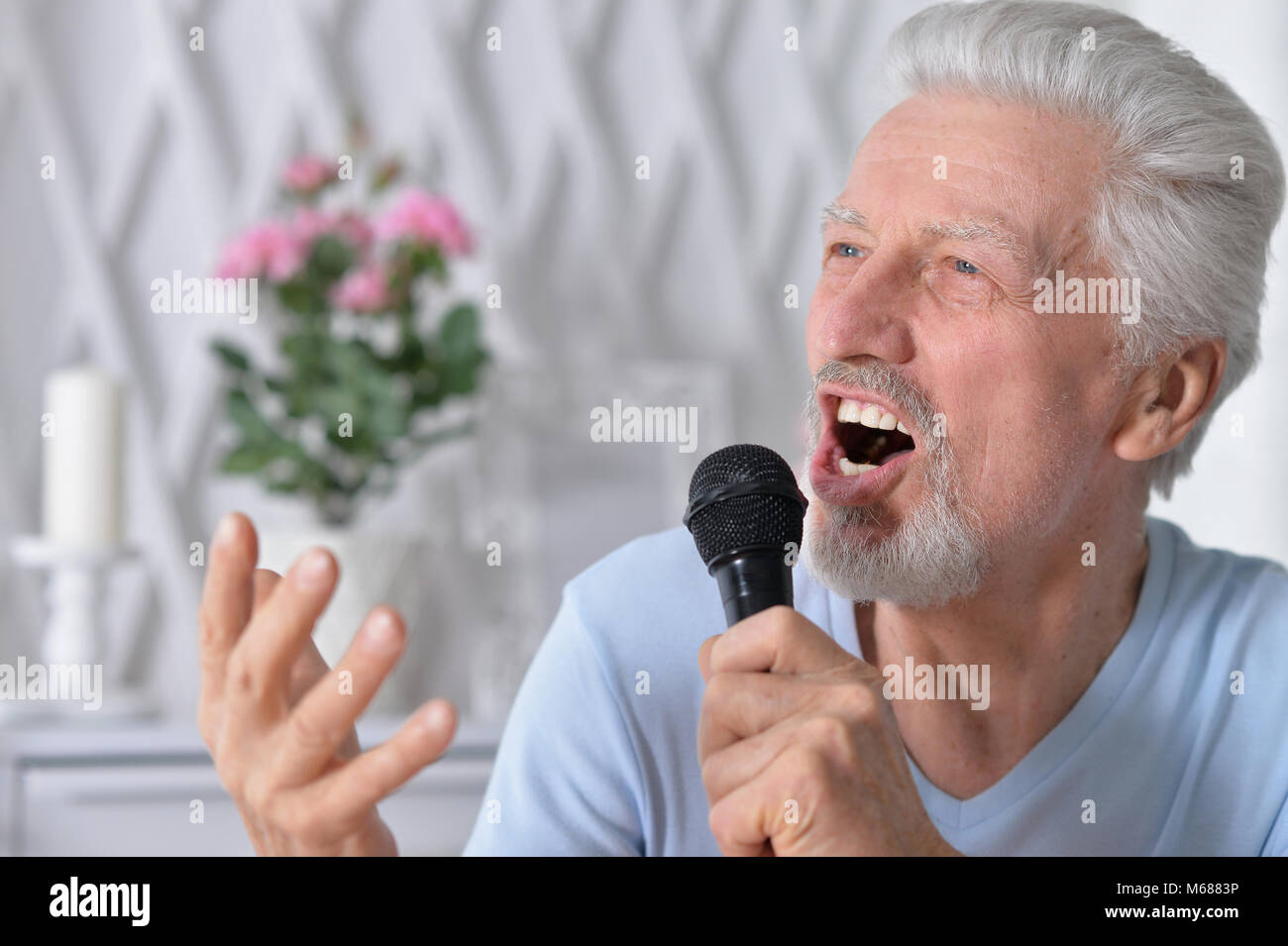 excited senior man holding microphone Stock Photo - Alamy