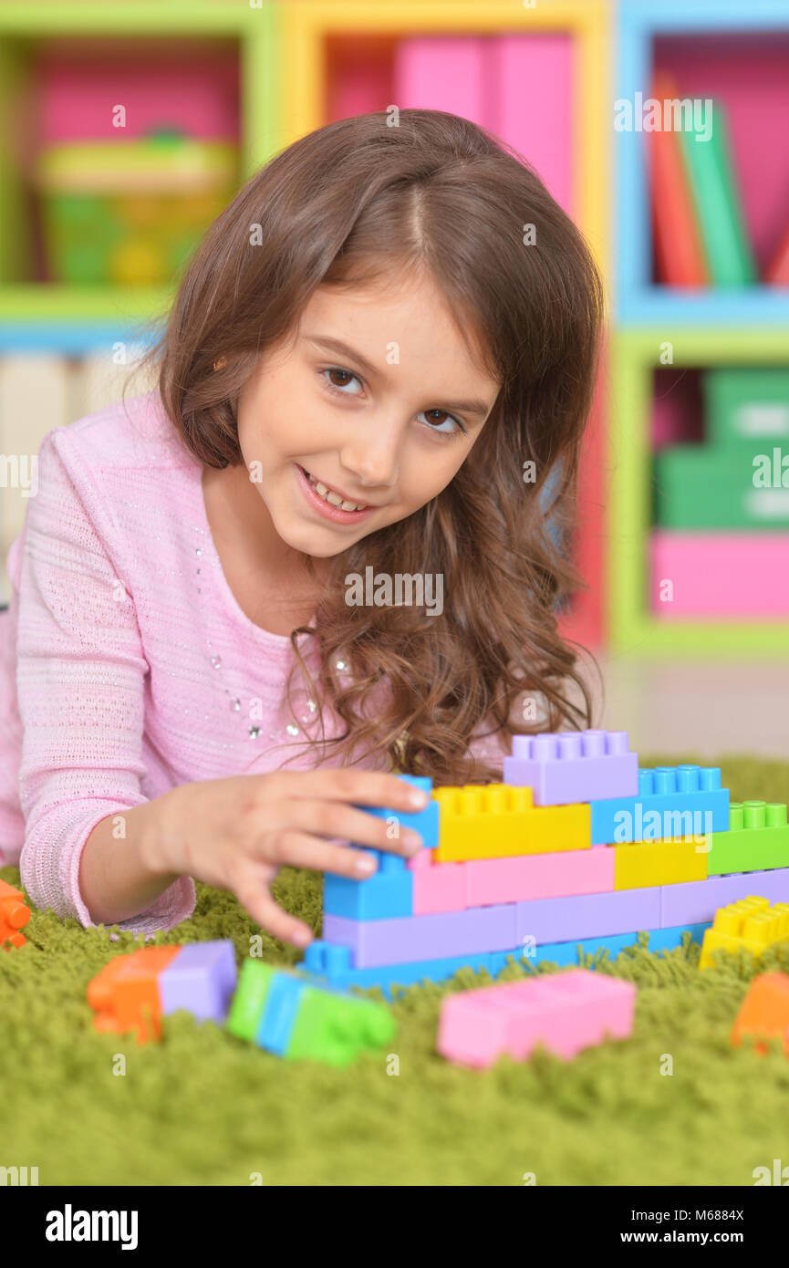 Cute girl playing with plastic blocks Stock Photo - Alamy