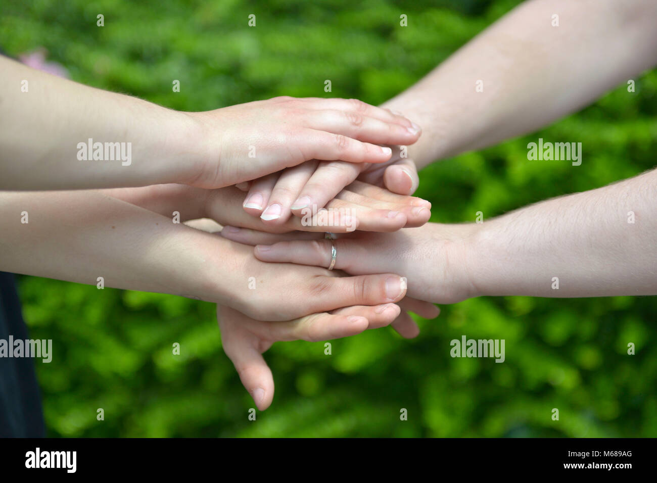 Hands of several persons lying on top of each other Stock Photo - Alamy