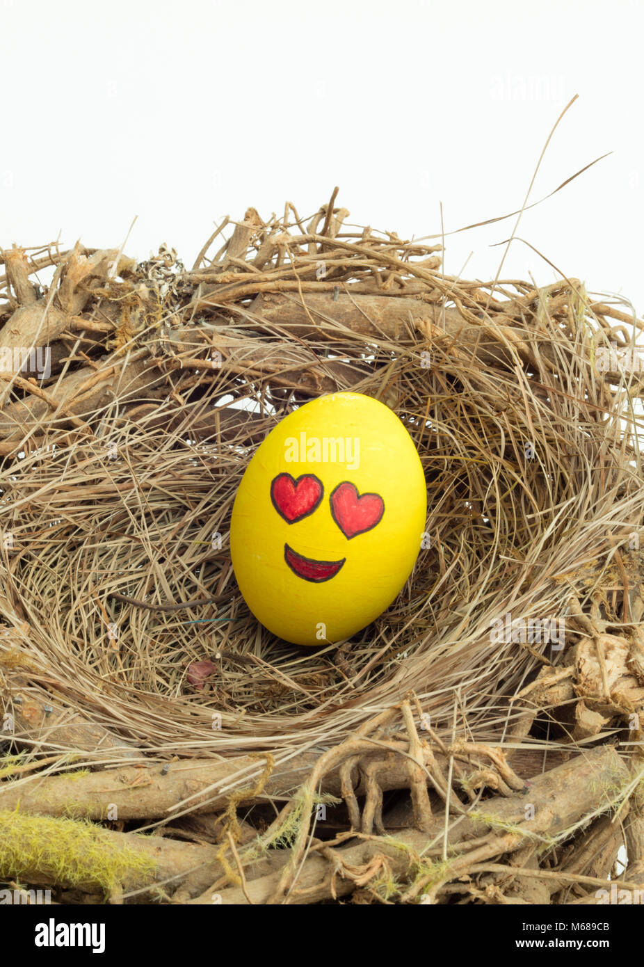 Two Easter eggs painted with emojis, one in love and other kissing ...