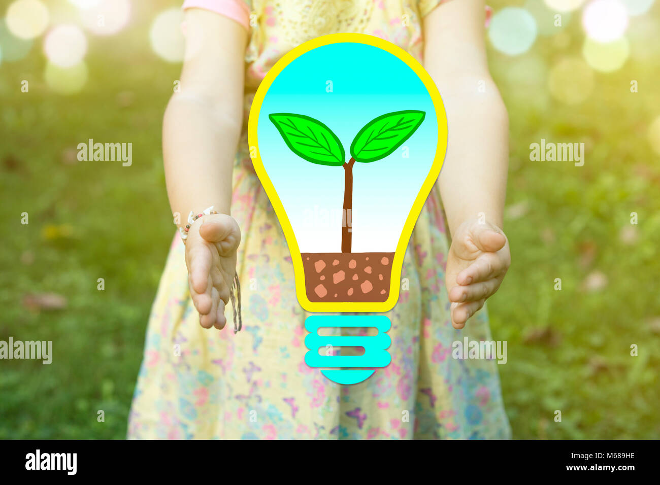 Child holding a bulb with a plant growing inside as "green thinking ...