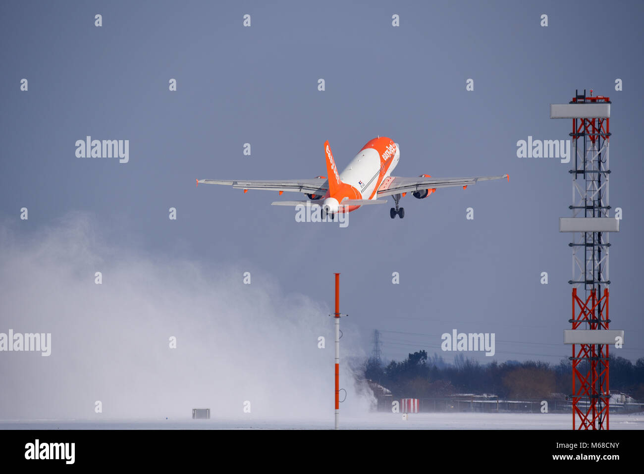 easyJet Airbus A319 jet plane pluming a cloud of snow as it takes off ...