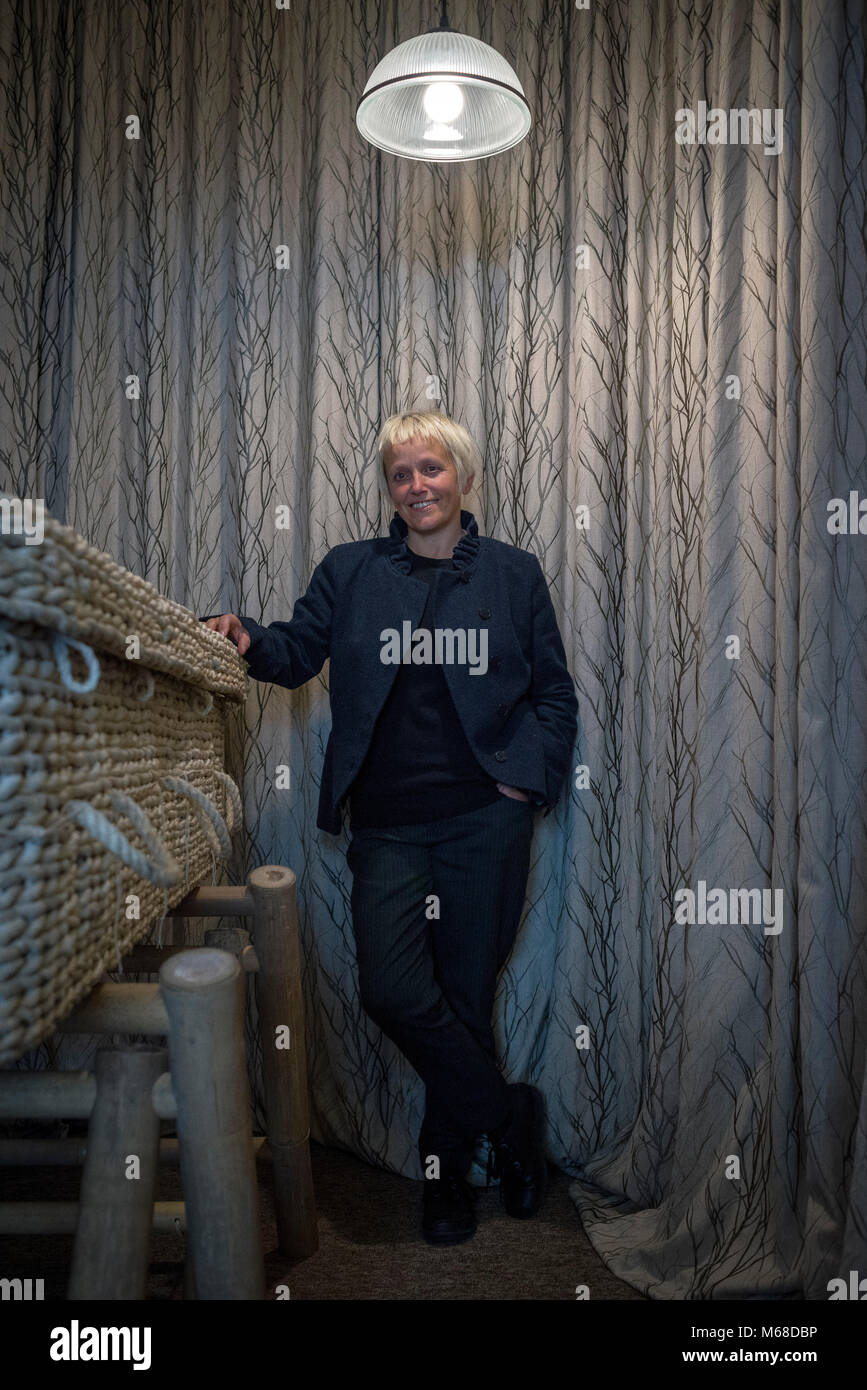 a friendly young funeral director / undertaker stands by a wicker ...