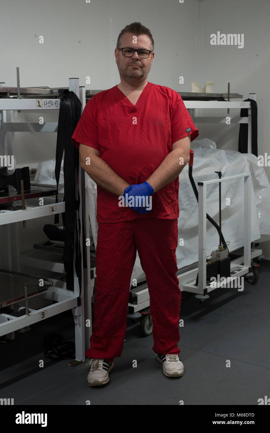 a male embalmer poses for a portrait behind the scenes in an ...