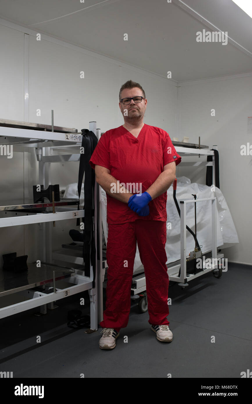 a male embalmer poses for a portrait behind the scenes in an ...