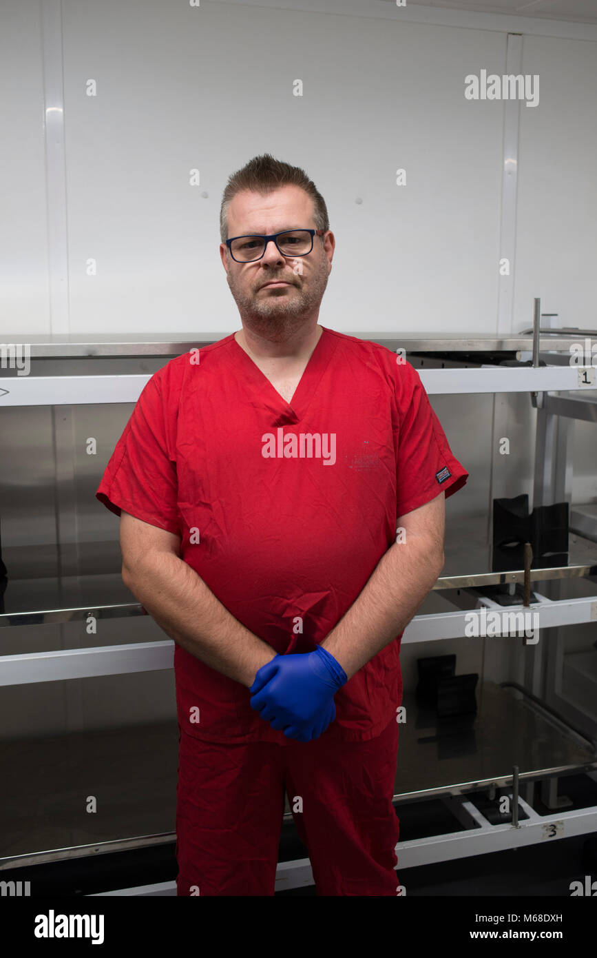 a male embalmer poses for a portrait behind the scenes in an ...