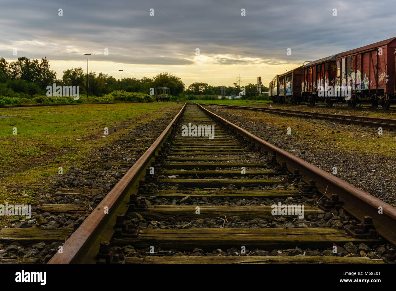 dramatic sunset over railroad on tracks Stock Photo - Alamy