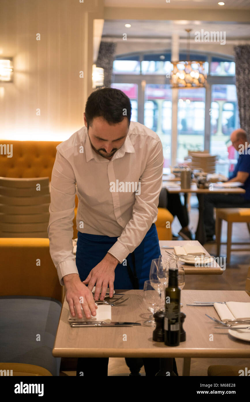 a male waiting staff working at a restaurant Stock Photo - Alamy