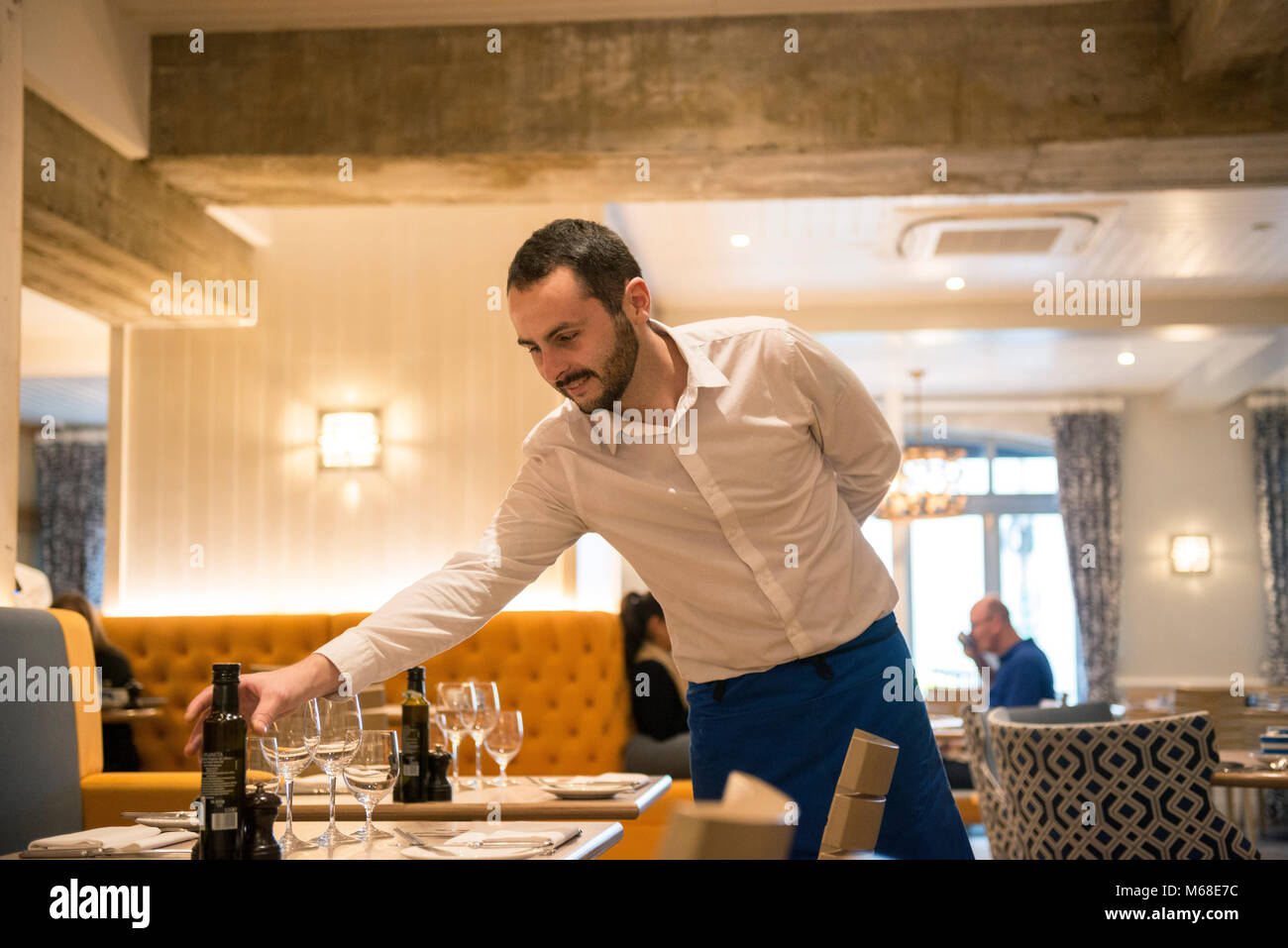 a male waiting staff working at a restaurant Stock Photo - Alamy