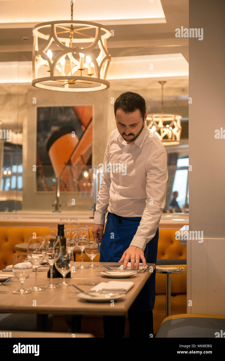 a male waiting staff working at a restaurant Stock Photo - Alamy