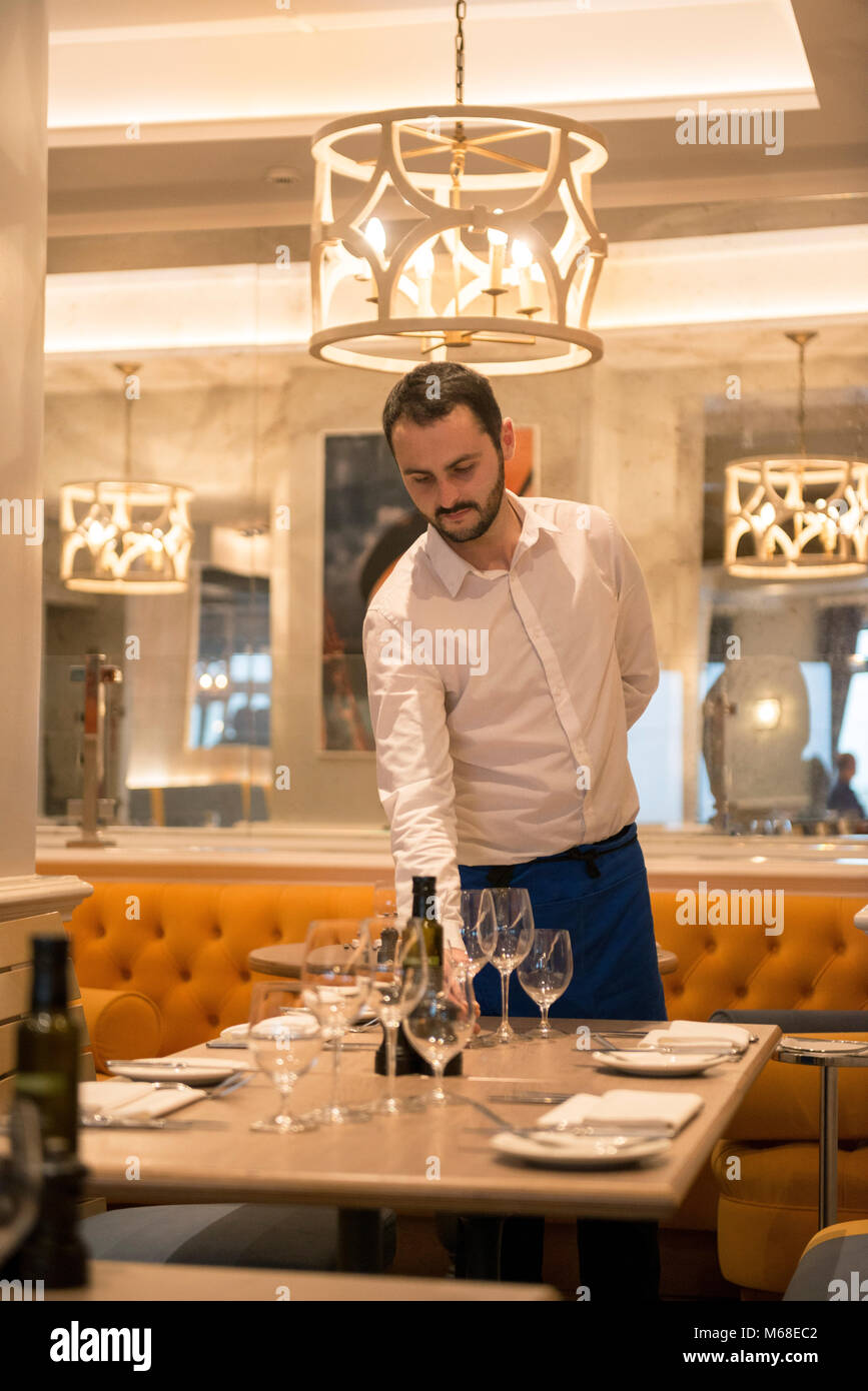 a male waiting staff working at a restaurant Stock Photo - Alamy