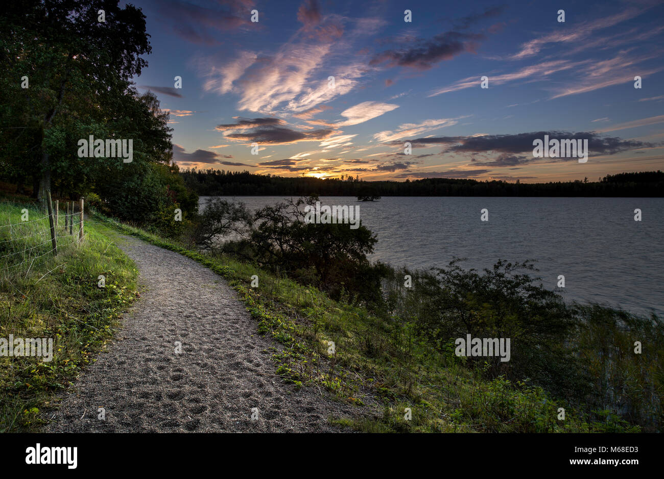 path beside a lake at sunset Stock Photo - Alamy