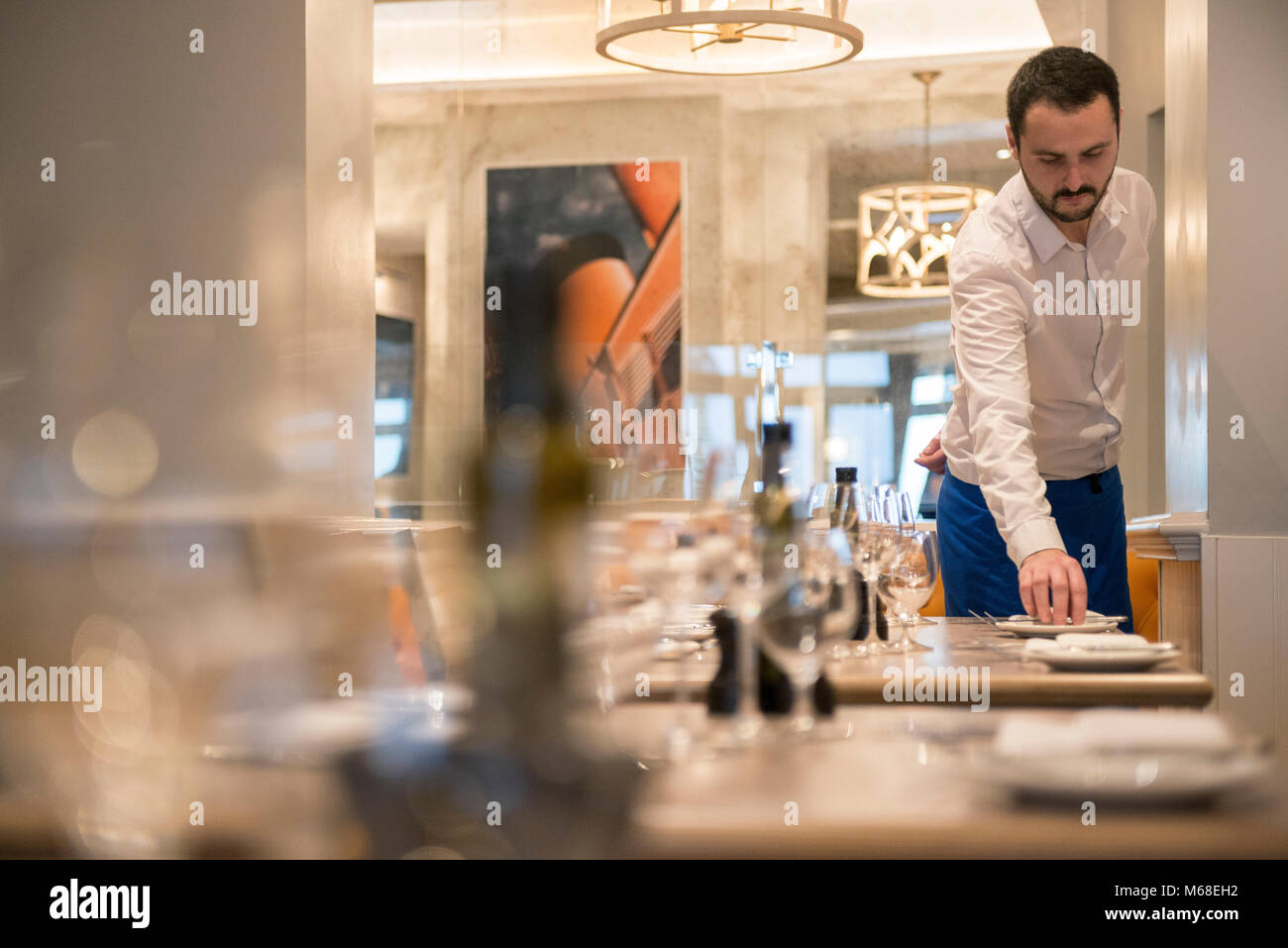 a male waiting staff working at a restaurant Stock Photo - Alamy