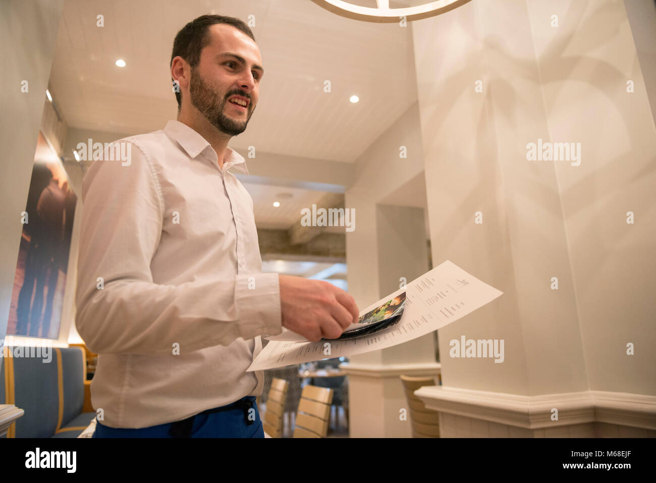 a male waiting staff working at a restaurant Stock Photo - Alamy