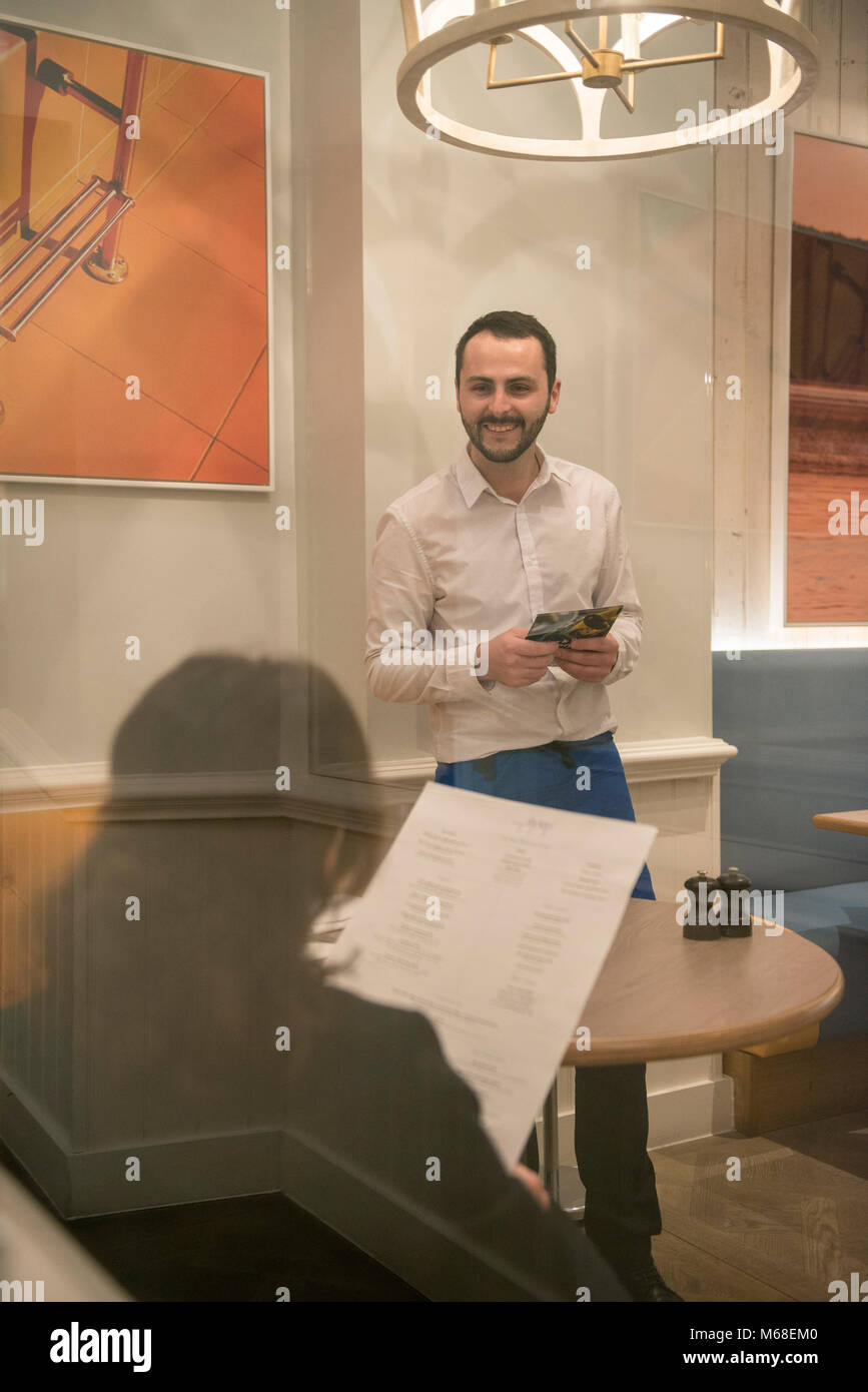 a male waiting staff working at a restaurant Stock Photo - Alamy