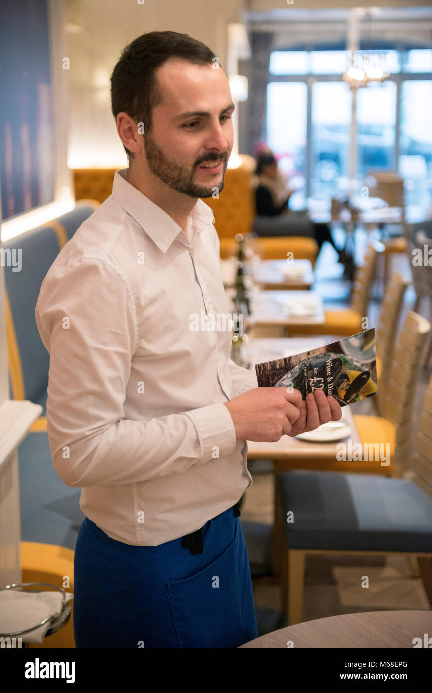 a male waiting staff working at a restaurant Stock Photo - Alamy