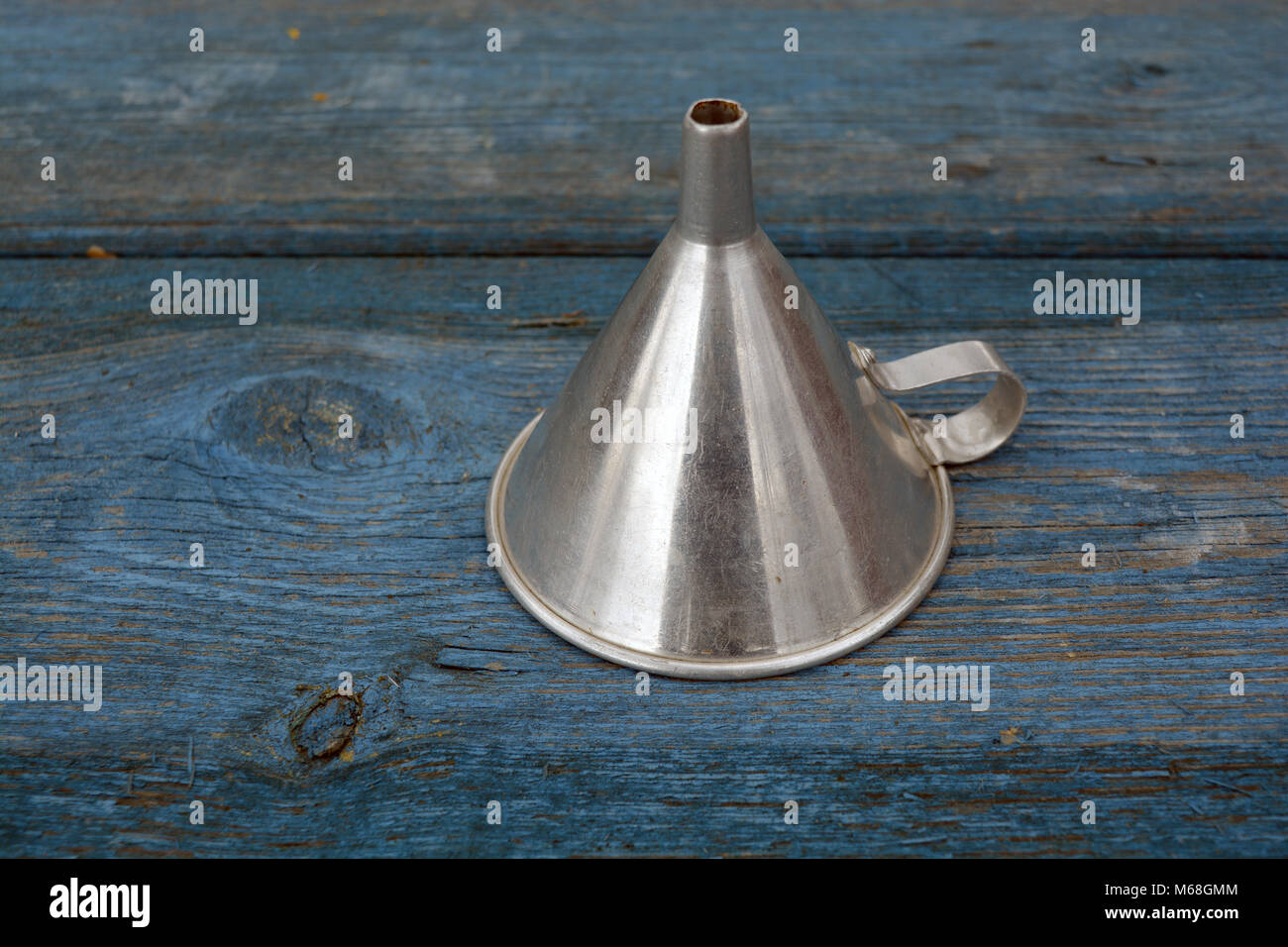 Retro metal funnel with handle on old wooden blue garden table ...