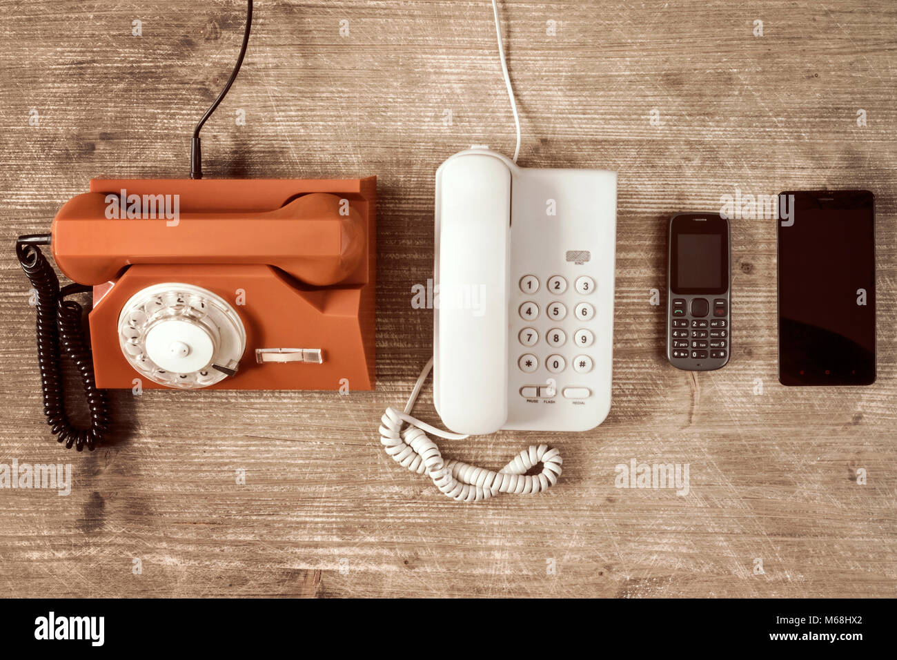 Old telephones and modern mobile phone show evolution in ...