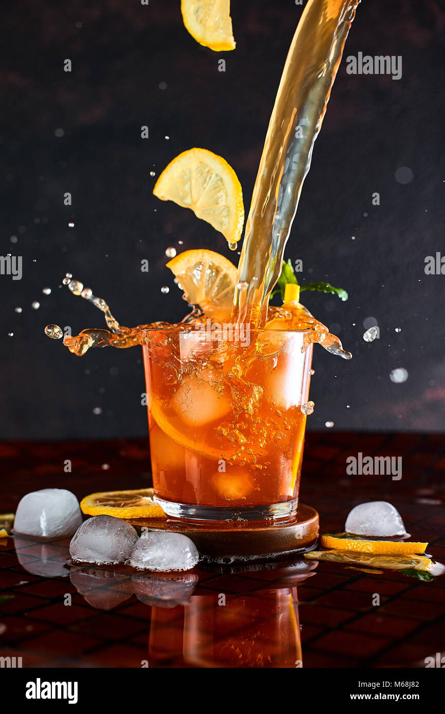 Iced lemon tea on dark background in glass and flying in air ...