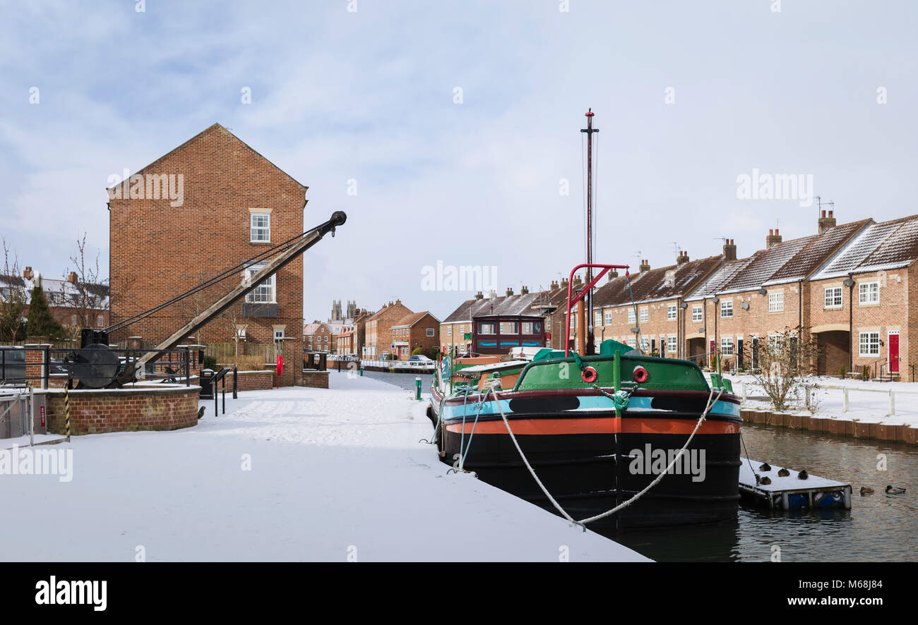 Urban scene with restored barge on canal, town houses, and minster ...