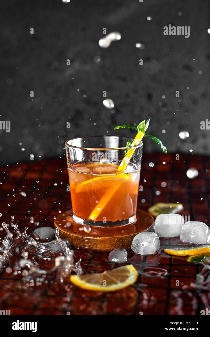 Iced lemon tea on dark background in glass and flying in air ...