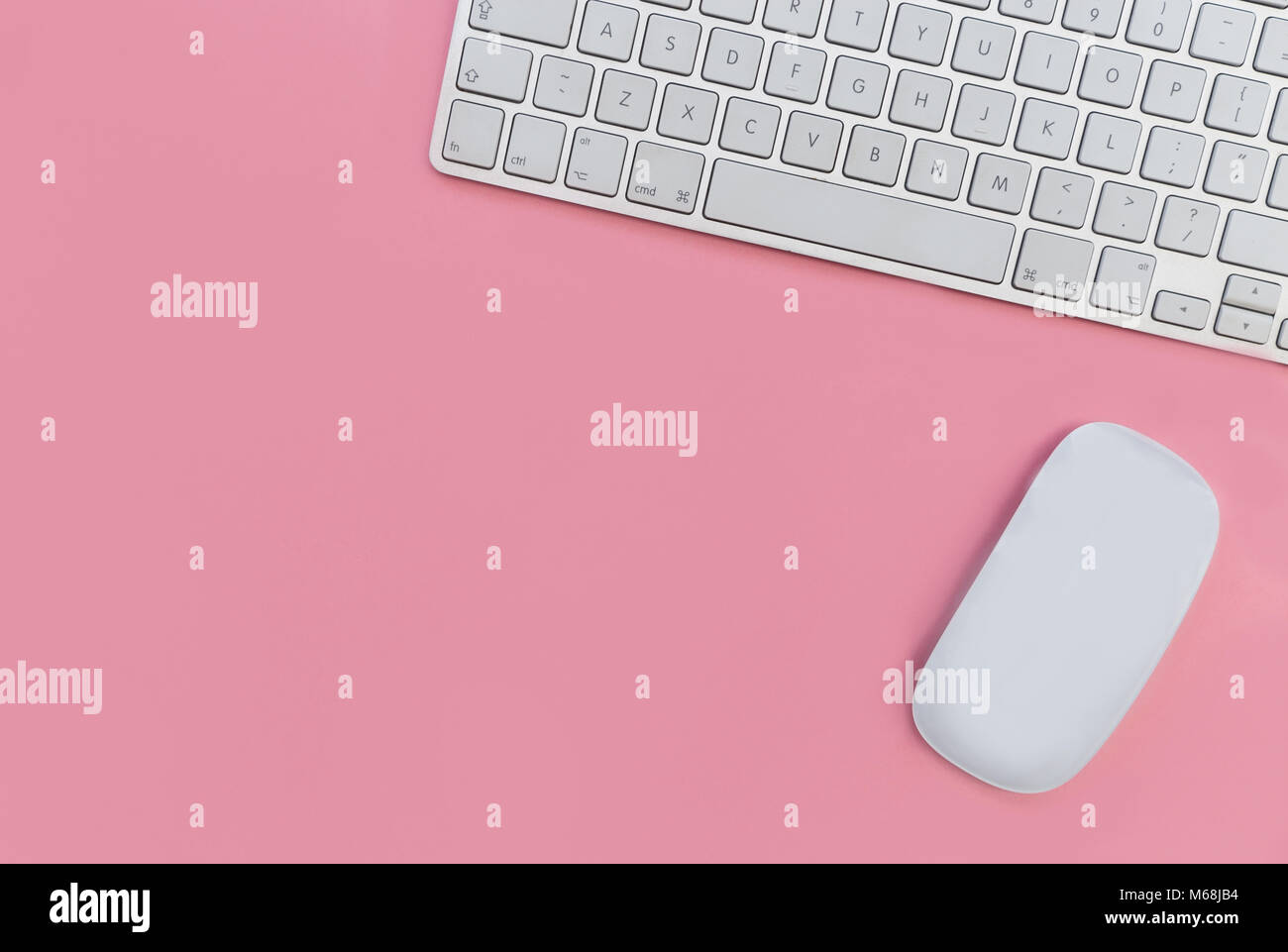 Computer keyboard and mouse overhead on pink background Stock Photo - Alamy