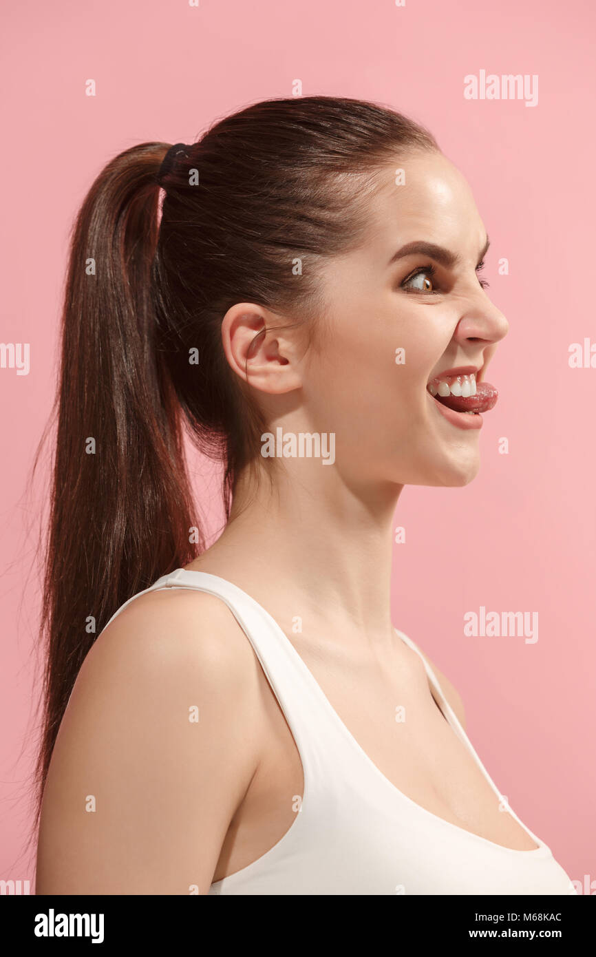 The young woman is looking crazy on the pink background Stock Photo - Alamy
