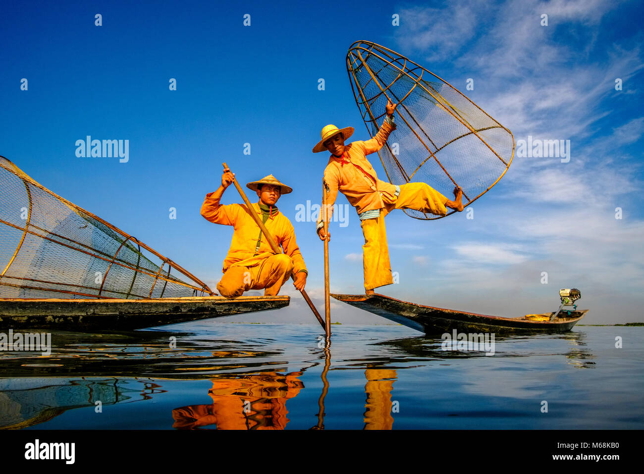 Fishermen, standing on their boats, posing, are fishing the traditional ...