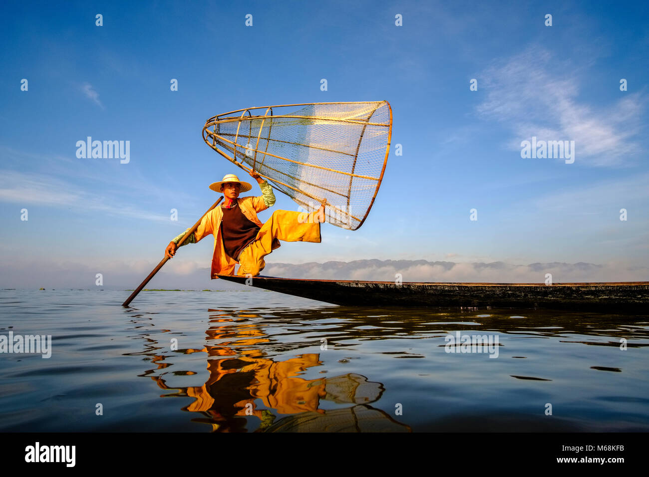A fisherman, sitting on his boat, posing, is fishing the traditional ...