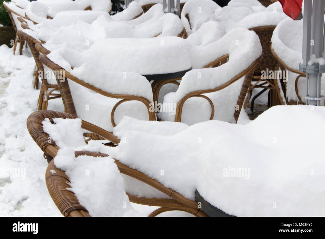 Tables and chairs of a cafe bar, covered with snow Stock Photo - Alamy