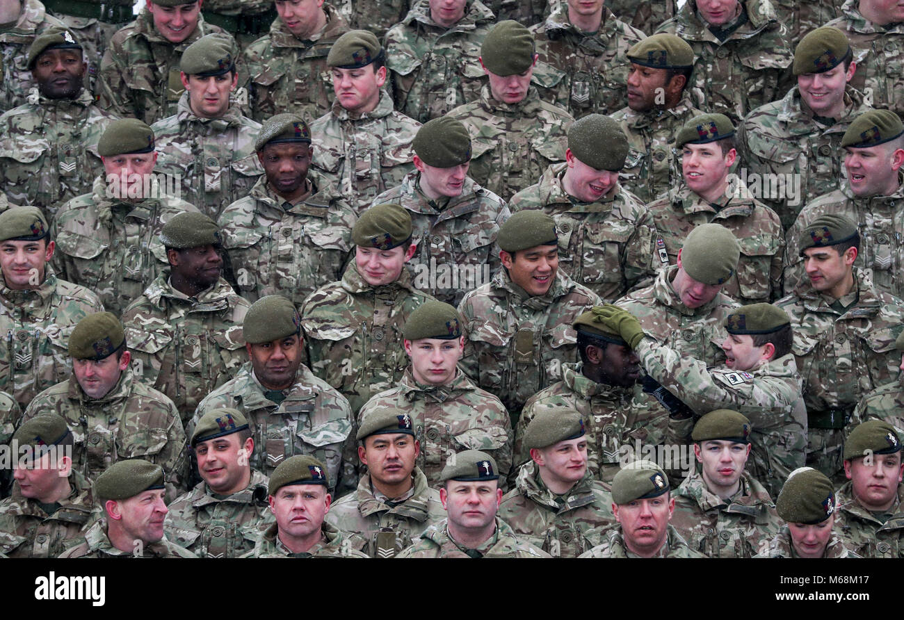 A member of the 1st Battalion Welsh Guards is helped with his beret for ...