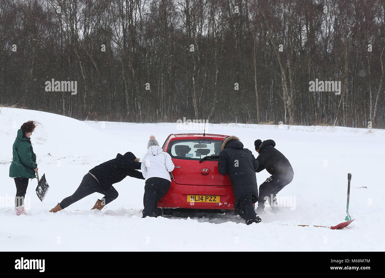 A car is pushed in snowy conditions in Larbert, near Falkirk, as storm ...