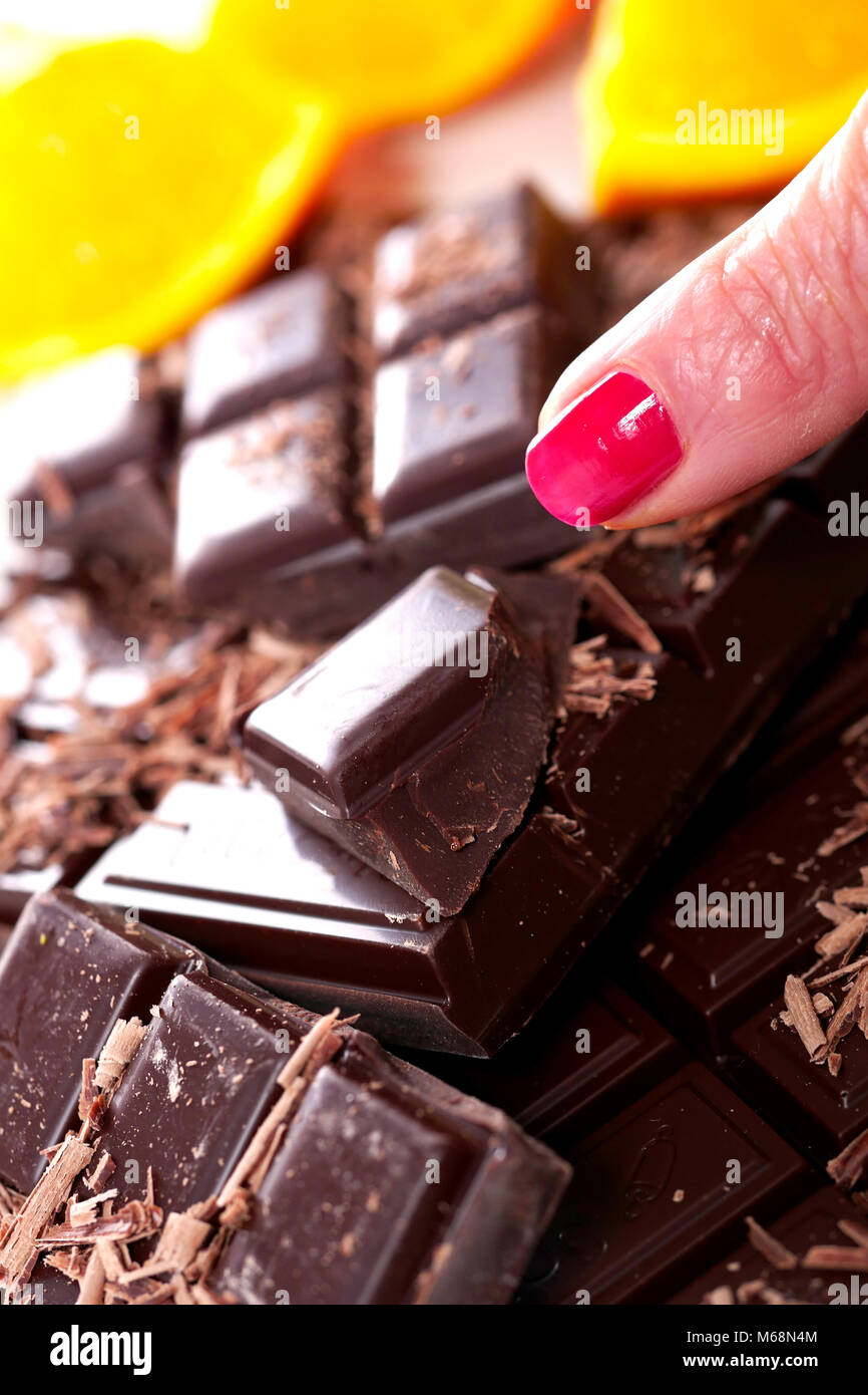 tablet and pieces of dark chocolate with the woman finger Stock Photo ...