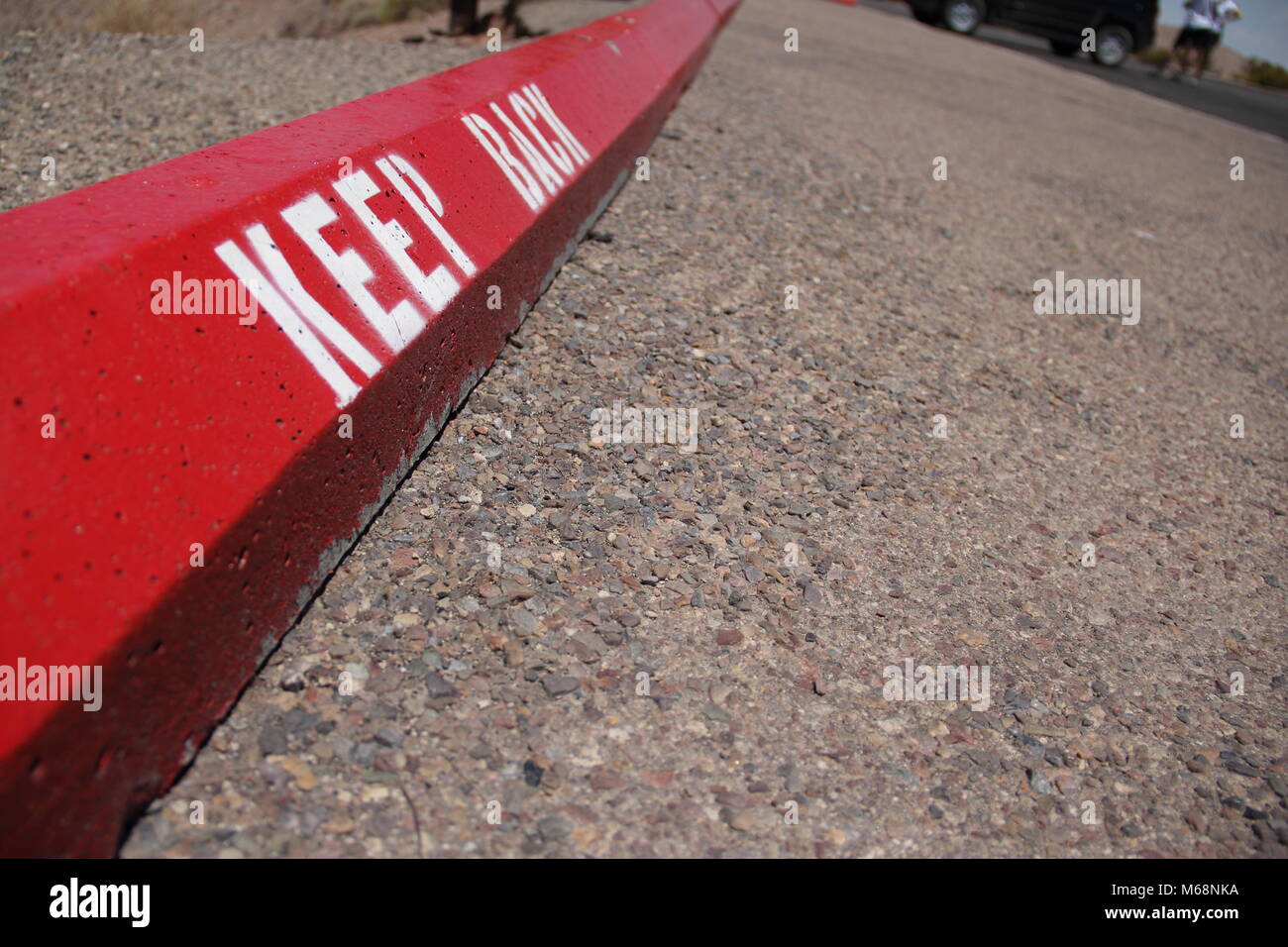 Keep Back warning road sign on the red concrete block with road, car ...