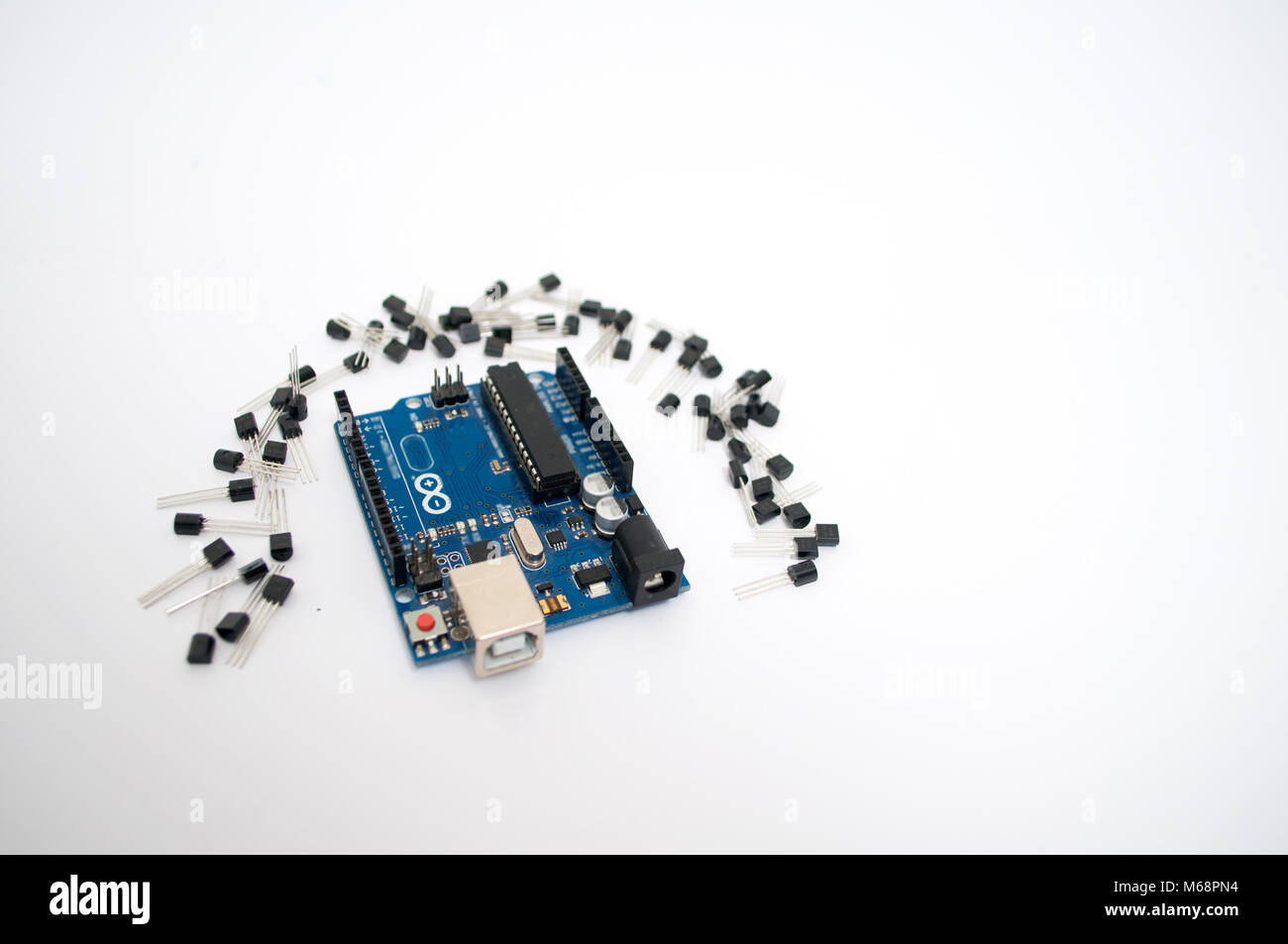Arduino, wires and around transistors lined up on a white background ...