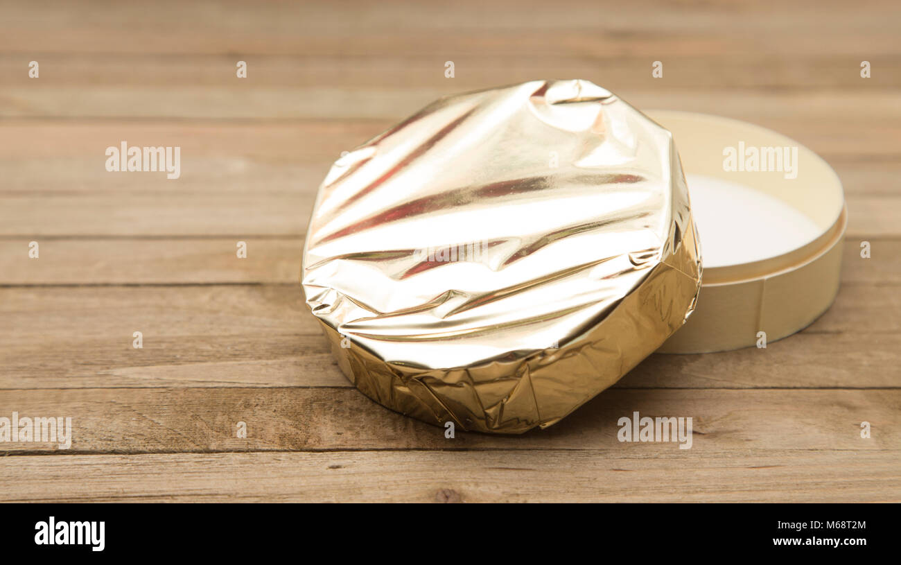 Beautiful Round of Soft Cheese with Gold Foil Wrapper Stock Photo - Alamy