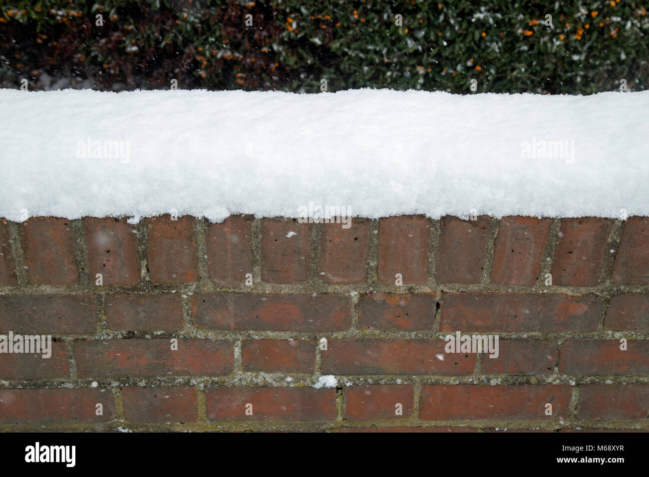 A red brick wall has a covering of snow Stock Photo - Alamy