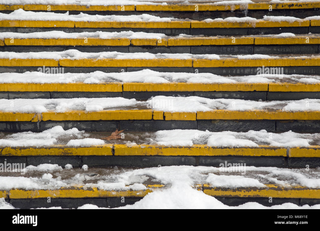 Snow on yellow lined steps Stock Photo - Alamy