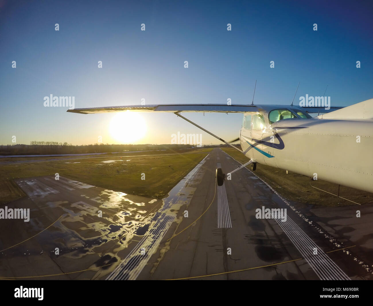 Small Airplane flying over the city during a vibrant winter sunset ...