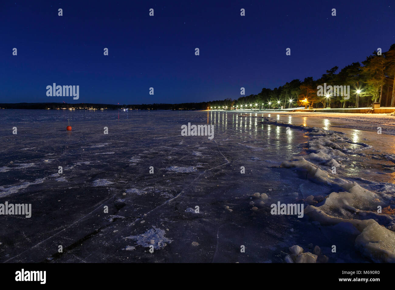 boardwalk a winter evening with ice on the lake Stock Photo - Alamy