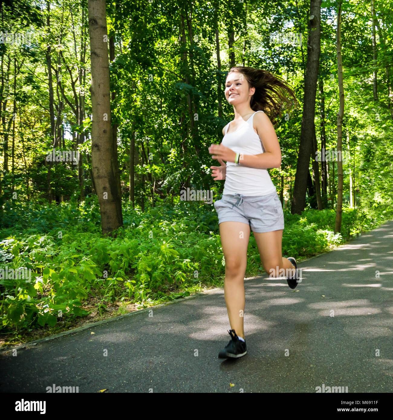 Teenage girl running, jumping in park Stock Photo - Alamy