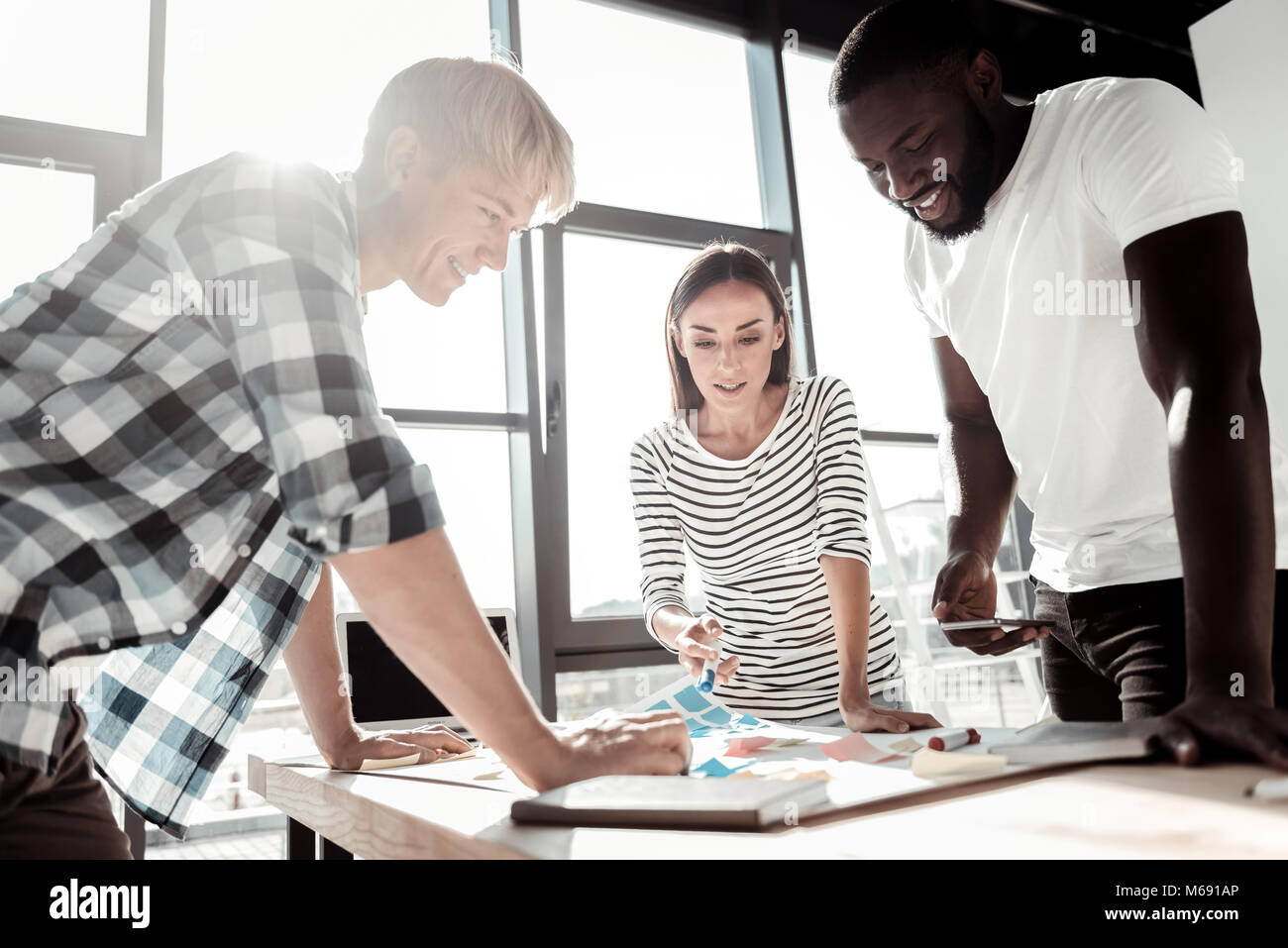 Nice smart colleagues looking at their project Stock Photo - Alamy