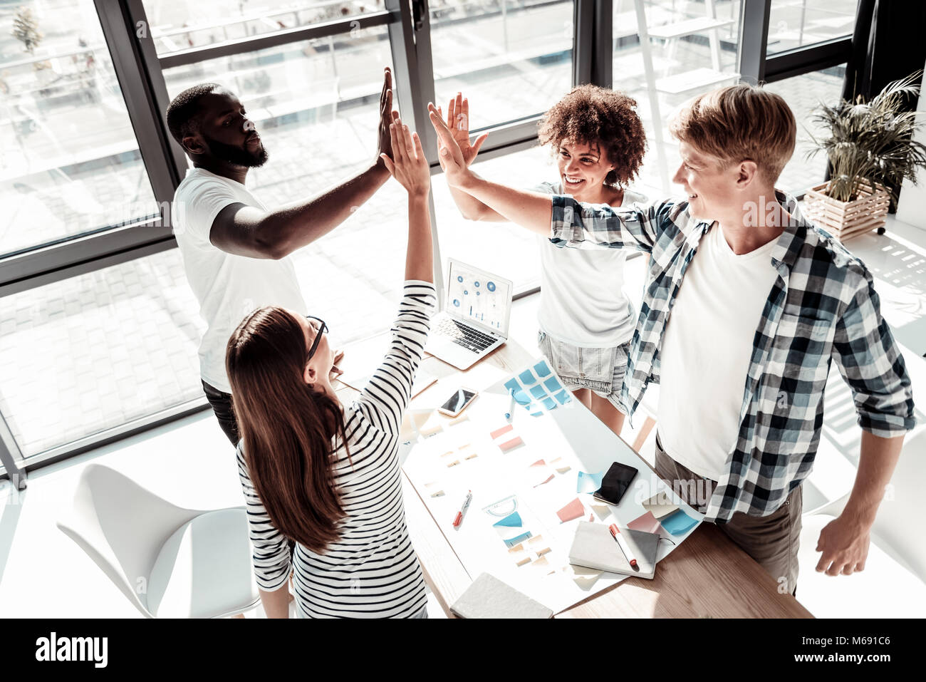 Cheerful delighted people giving each other high five Stock Photo - Alamy