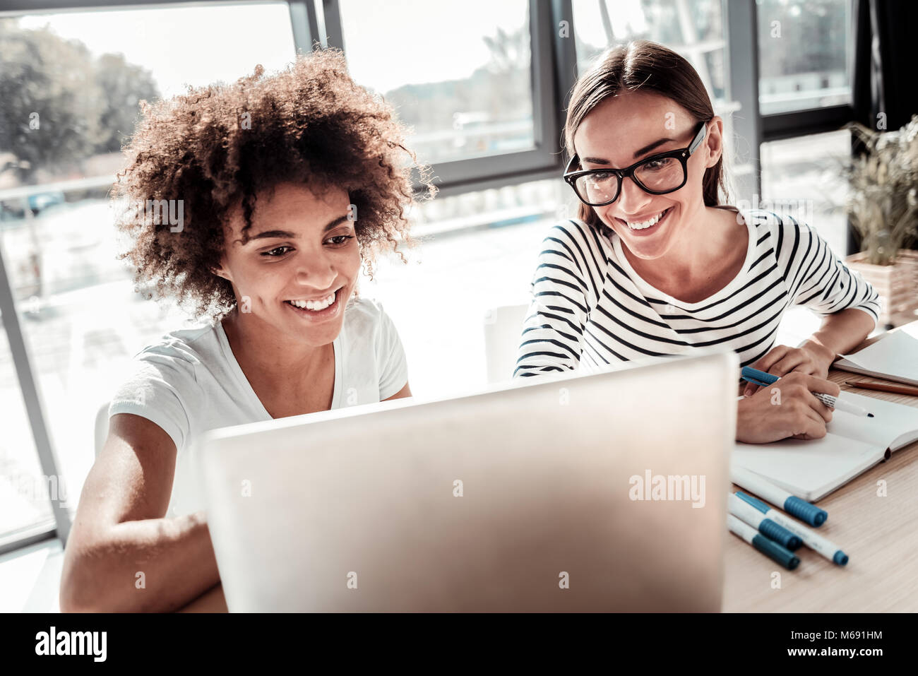 Happy delighted women working together Stock Photo - Alamy