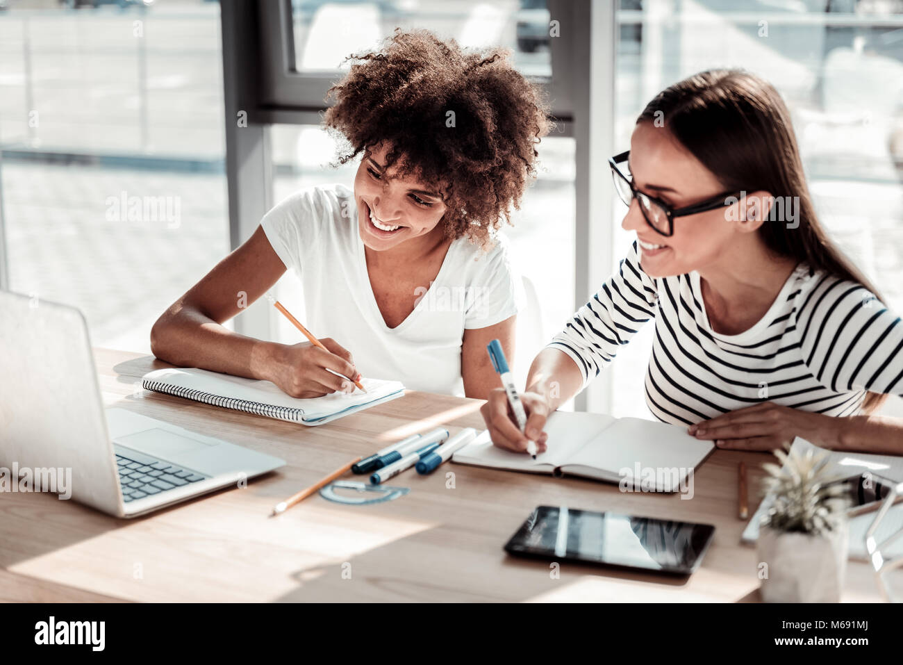 Happy smart women taking notes Stock Photo - Alamy
